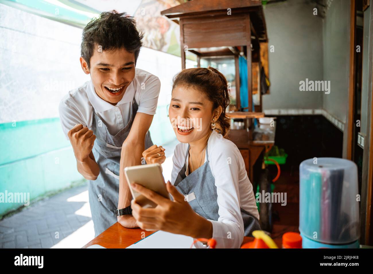 male and female sellers are excited to use mobile phones Stock Photo ...