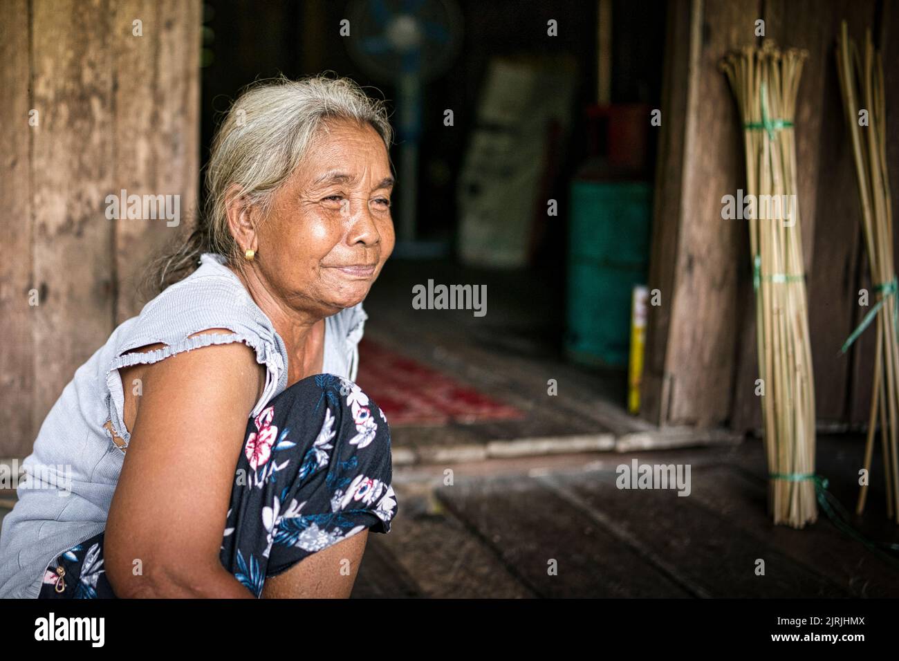 A close-up of single indigenous old woman sitting and smiling in Chini ...