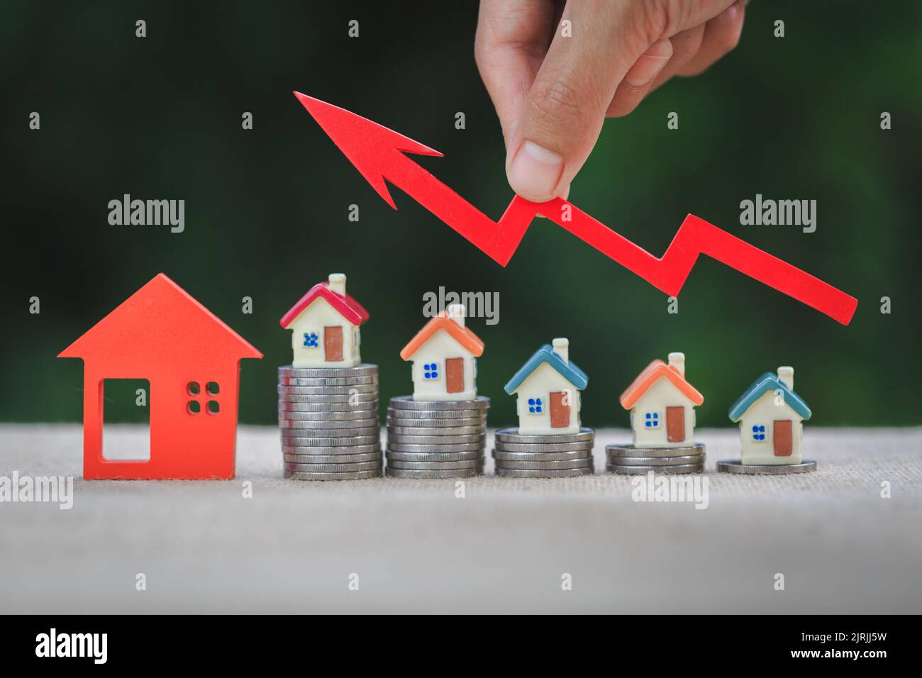 House model and a stack of coins. Real estate market, graph up arrow ...
