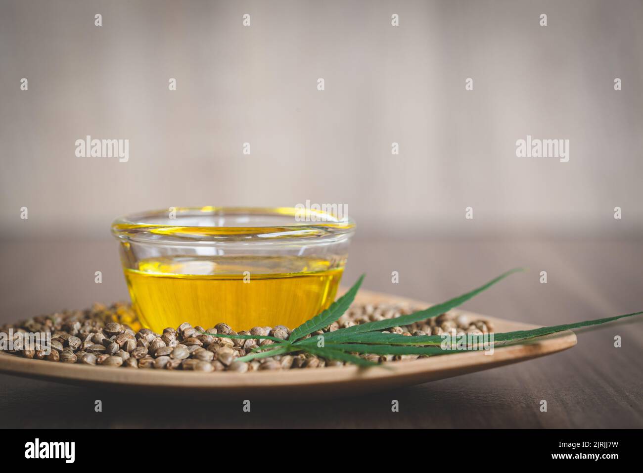 Hemp oil extracted in a bowl placed near the seeds and leaves ...