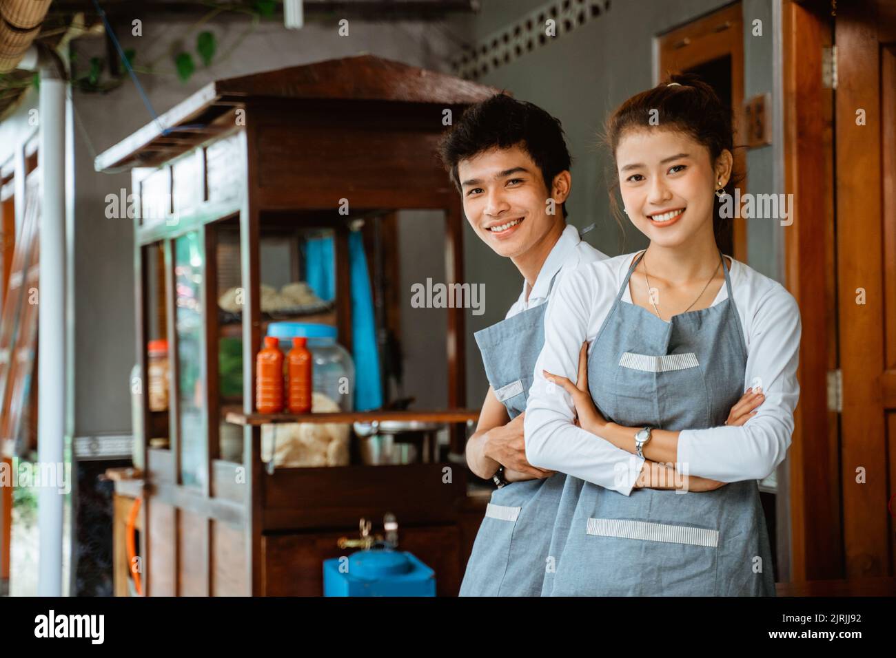 female and male waiters smiling with hands crossed Stock Photo - Alamy