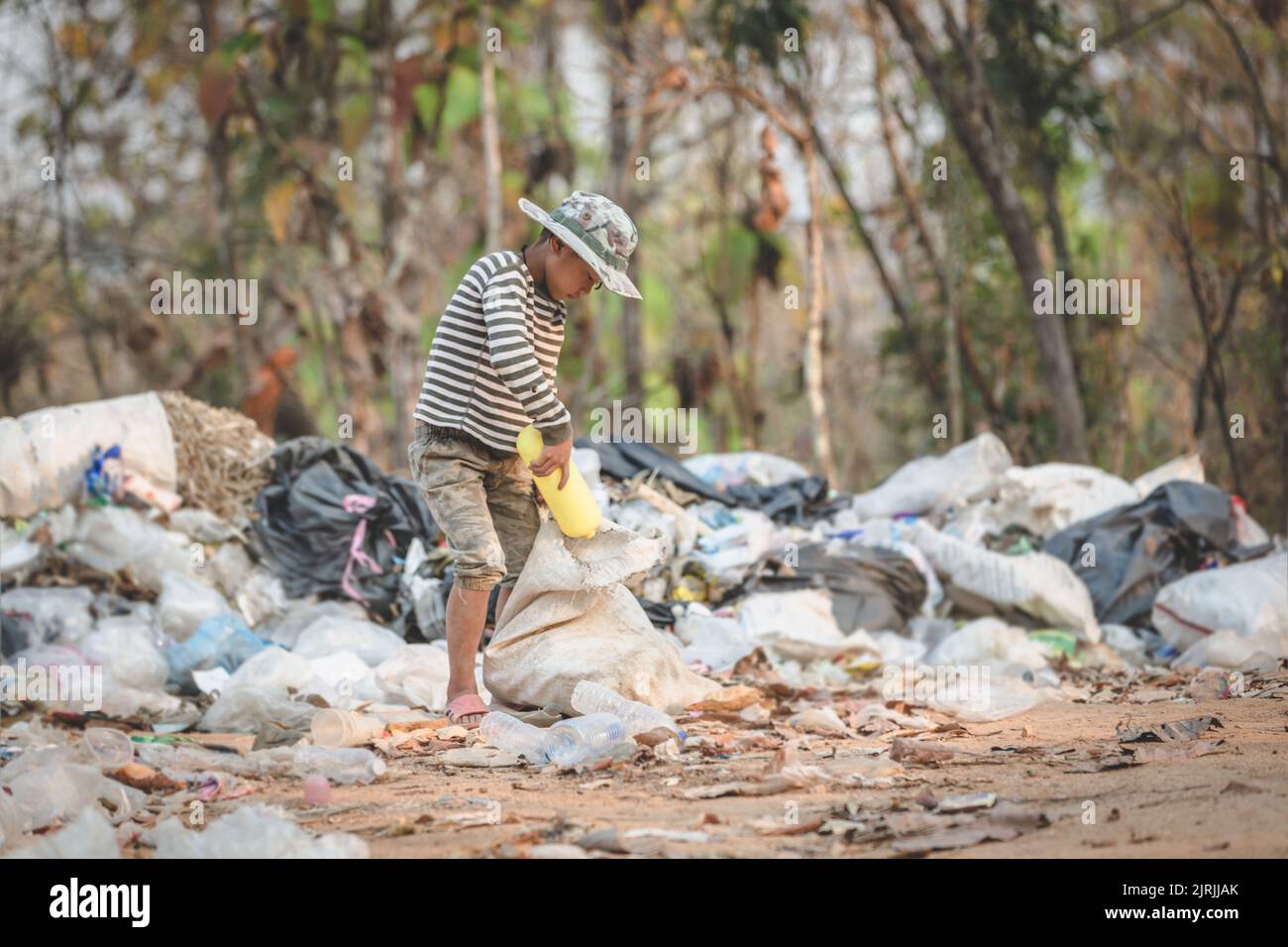 A poor boy collects trash from a landfill in the suburbs. Life and way ...