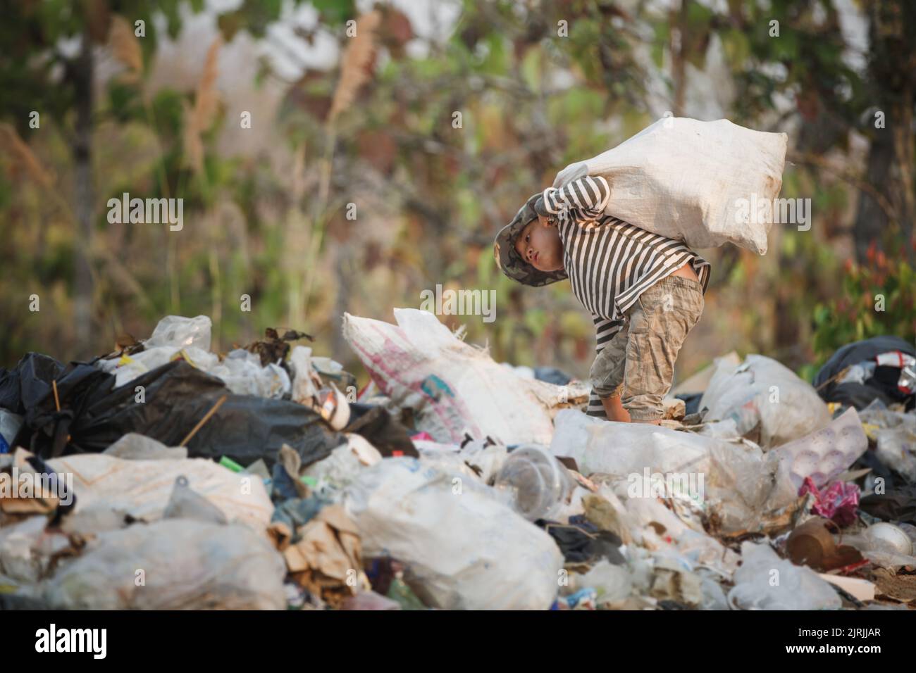 A poor boy collects trash to sell. Life and way of life of the poor ...