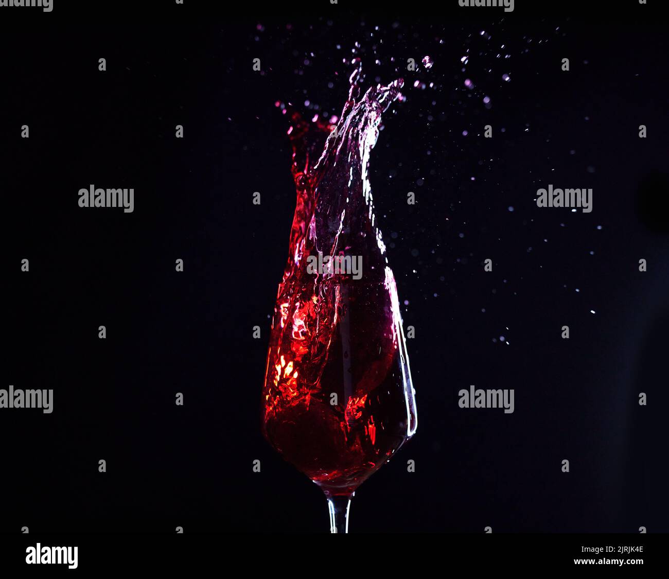 Wine, alcohol or drink glass and splash on black studio background for ...