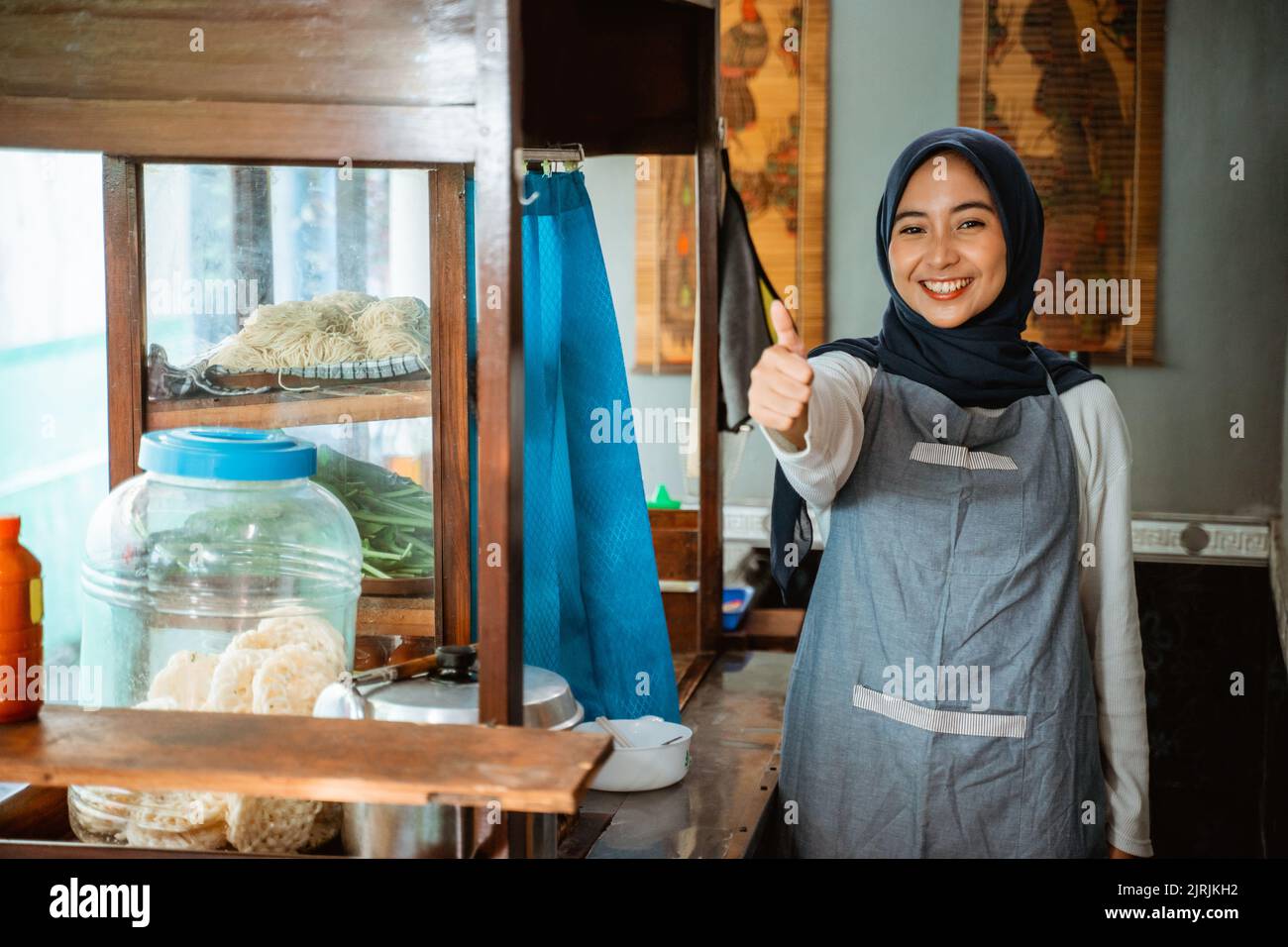 excited hijab woman wearing apron standing with thumbs up Stock Photo ...