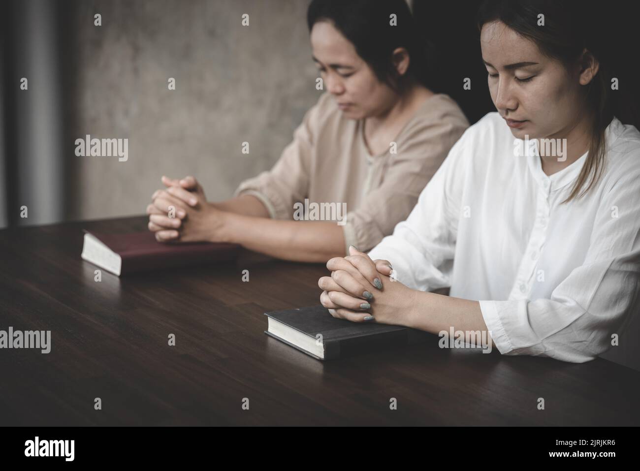 Two women laying hands on the Bible praying to God. Concept of ...