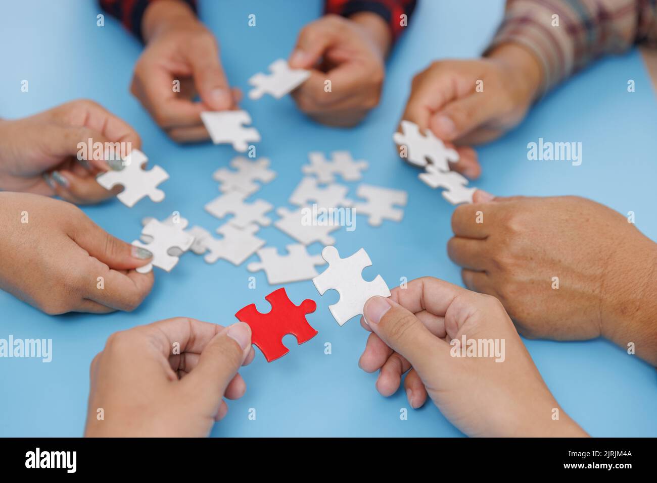 Group of business people assemble jigsaw puzzles on blue background ...