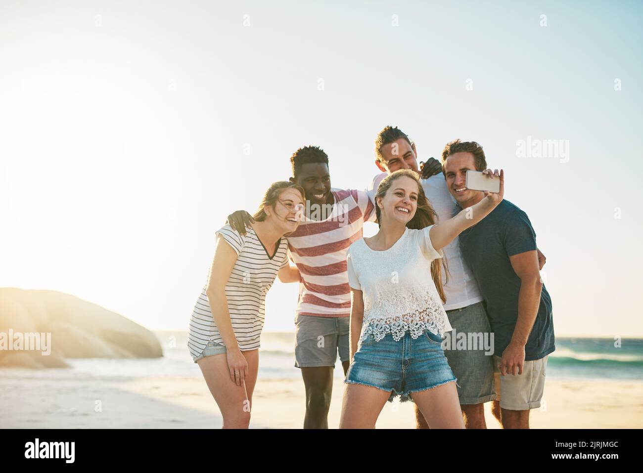 First selfie of summer. a happy group of friends taking selfies together at the beach Stock ...
