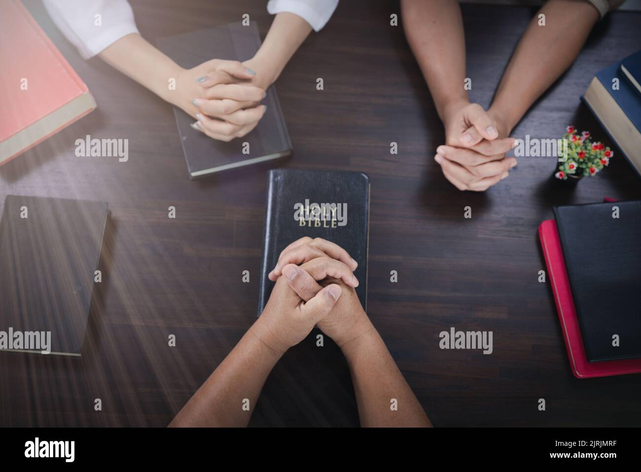 A group of Asian Christians sits inside a Catholic Church praying for ...