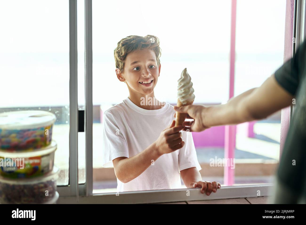 Hes an ice-cream enthusiast. a happy young boy getting an ice-cream ...