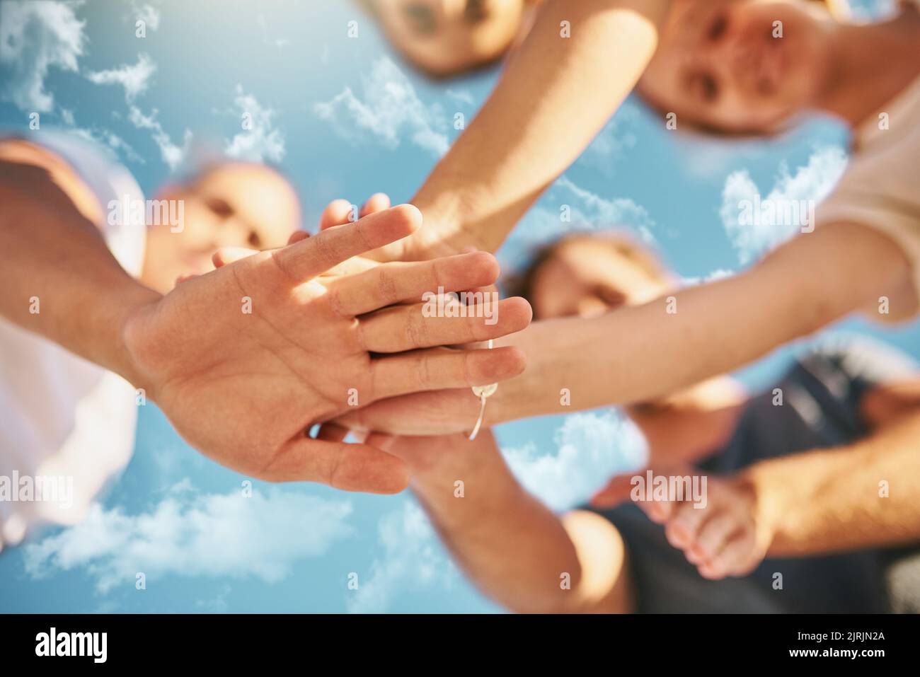 The ties that bind. Low angle shot of a group of young joining their ...