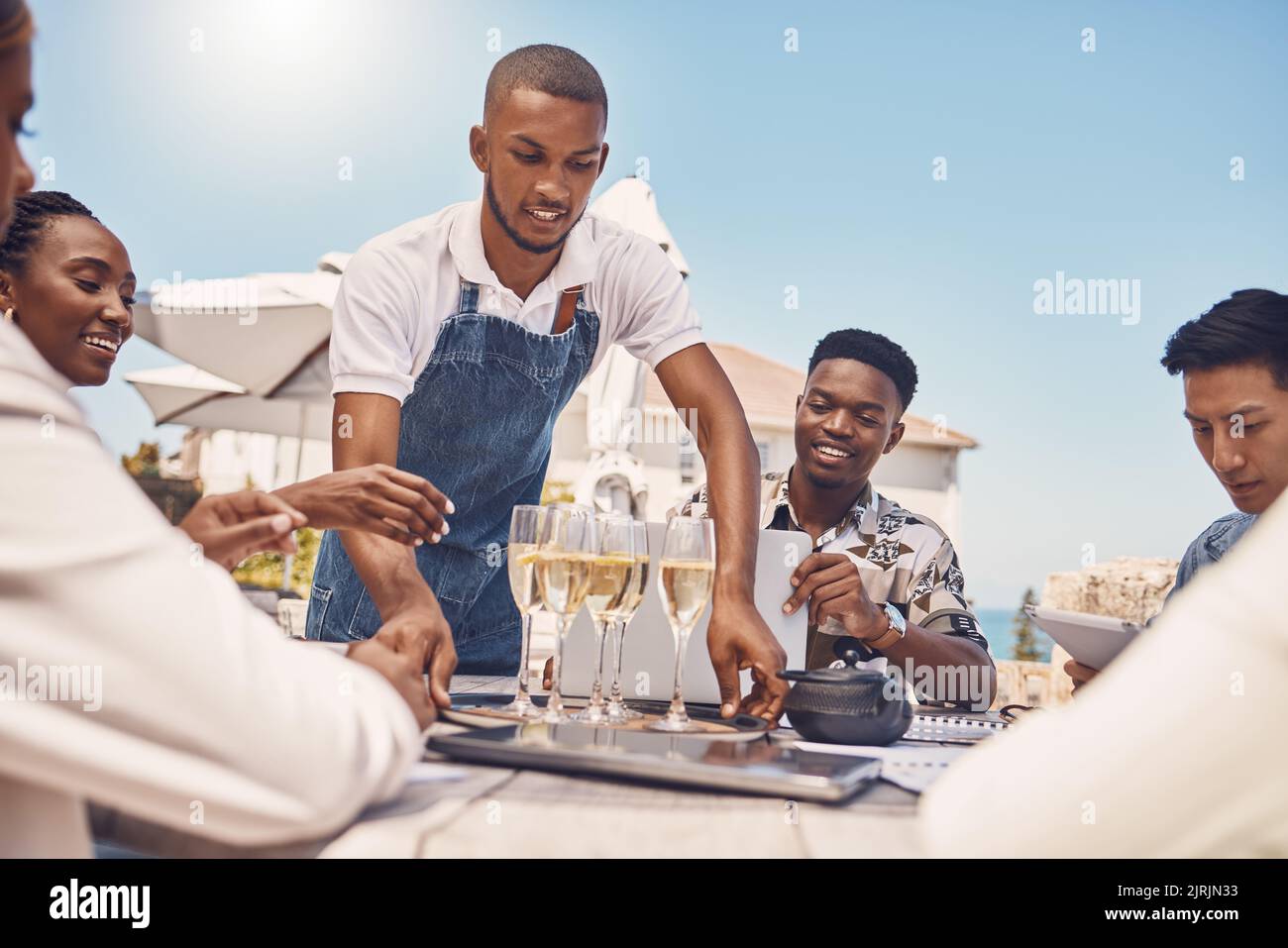 Beach restaurant, waiter and champagne celebration with friends ...