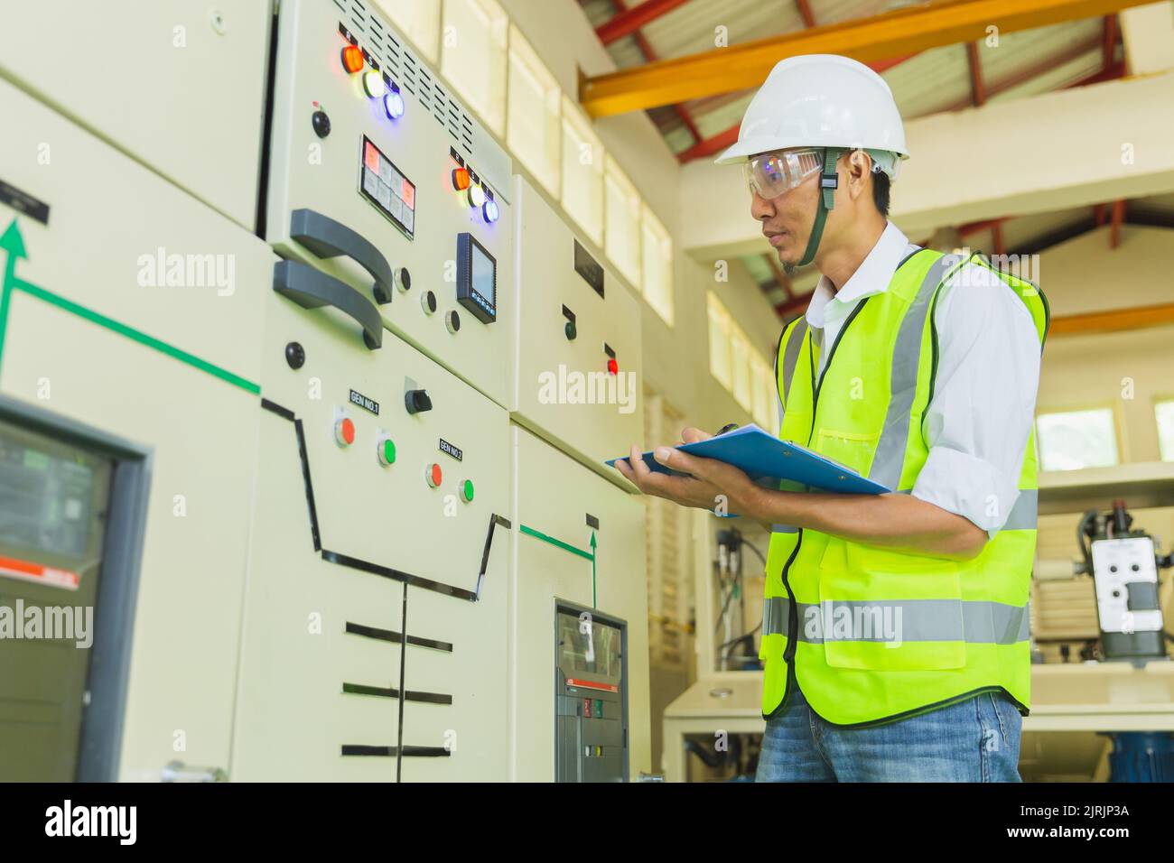 Experienced electrician working in power plant control room. Engineer ... Experienced electrician working in power plant control room. Engineer ...