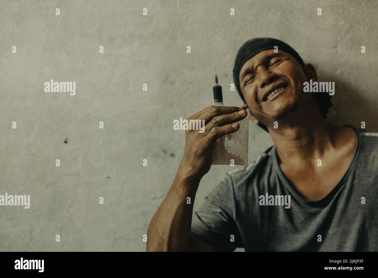 Drug addict man with syringe using drugs. Drugs concept. Dark theme ...