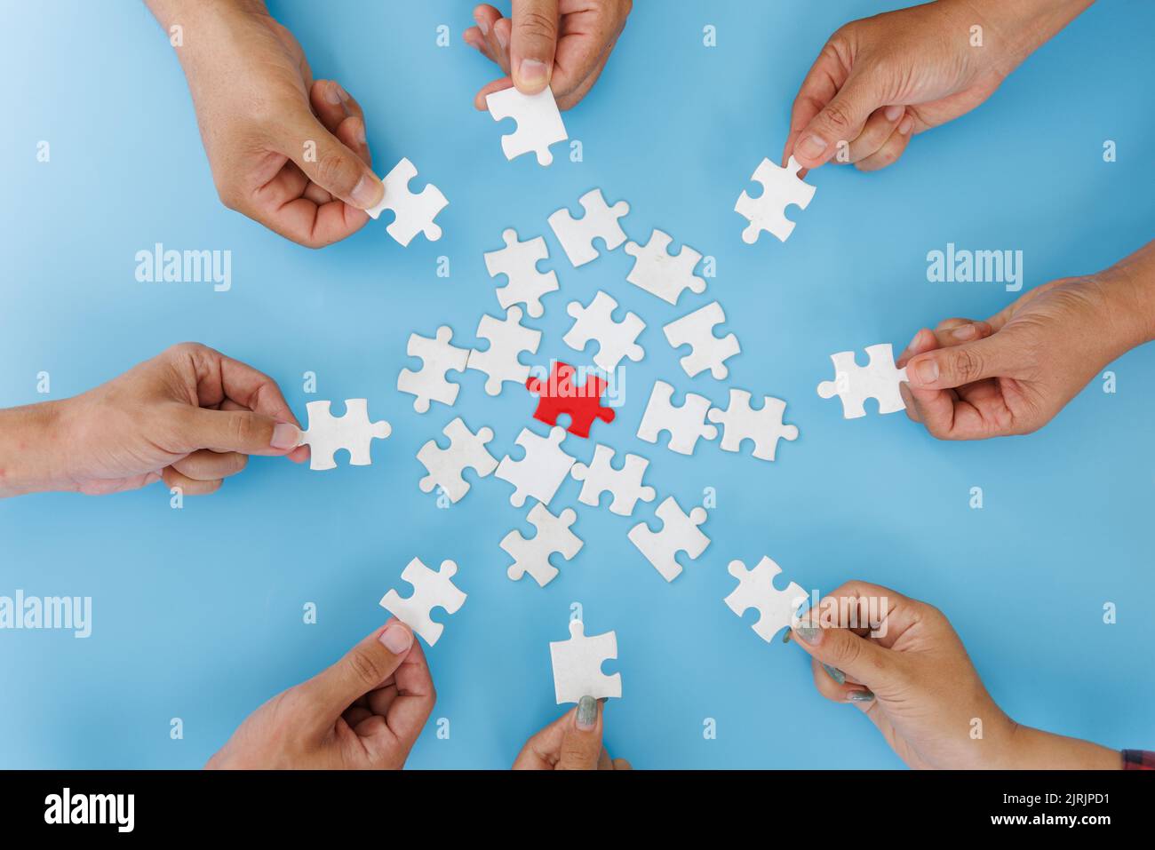 Hands of diverse people assembling jigsaw puzzle, team put pieces ...