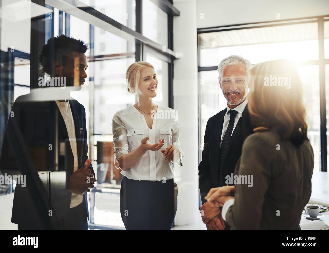 Getting some feedback from the team. four businesspeople talking while ...