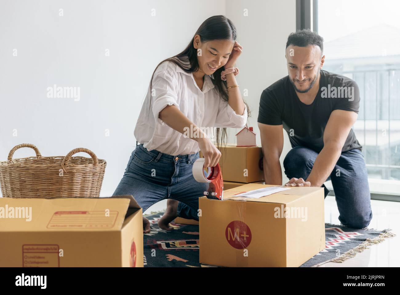 Young couple with big box in their new house, Carrying things into a ...