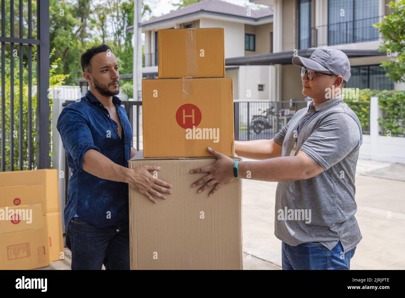 A couple with a big box in their new home. Carrying things into a new ...