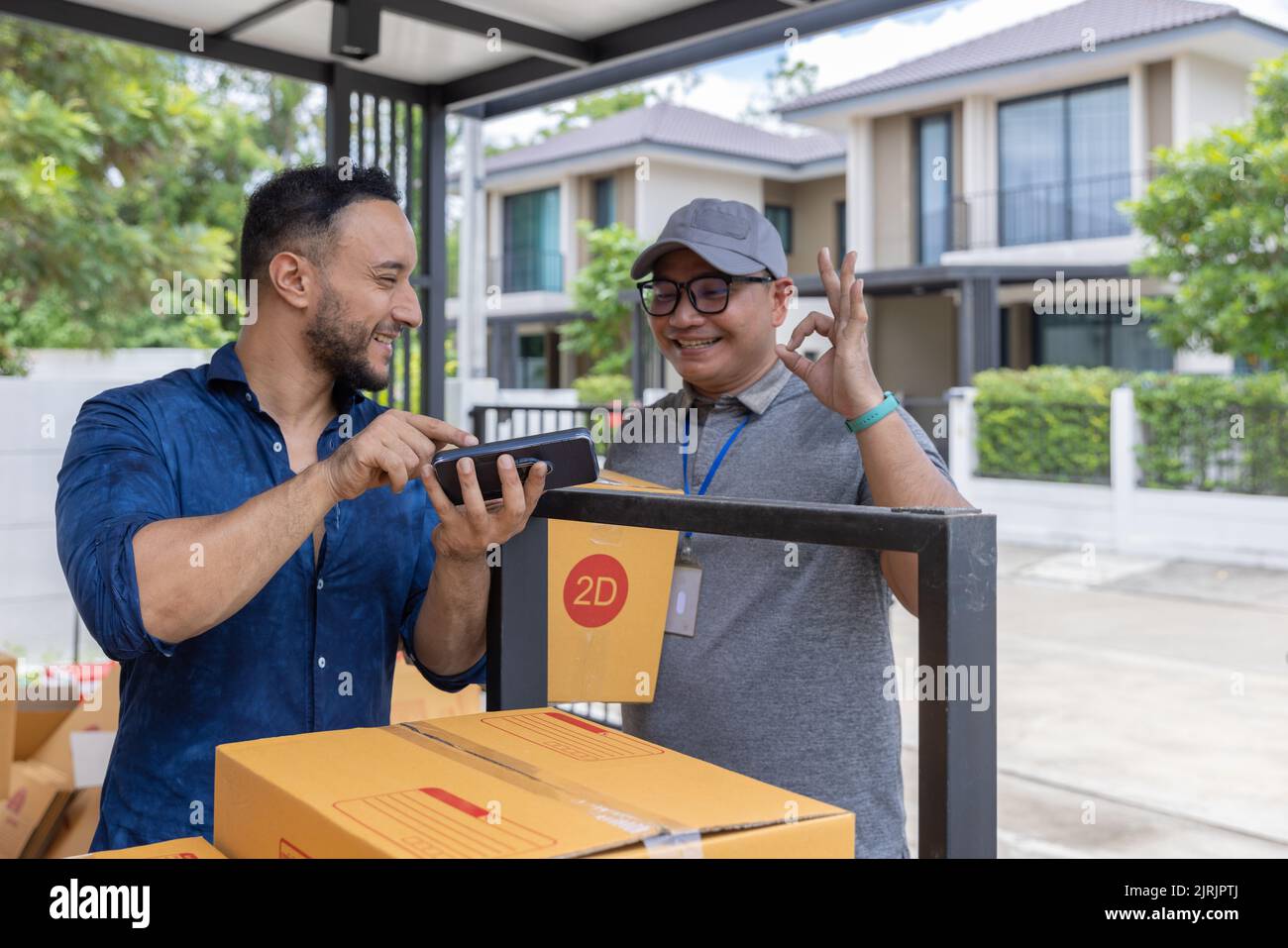 Two men check cardboard boxes, Carrying things into a new home Stock ...
