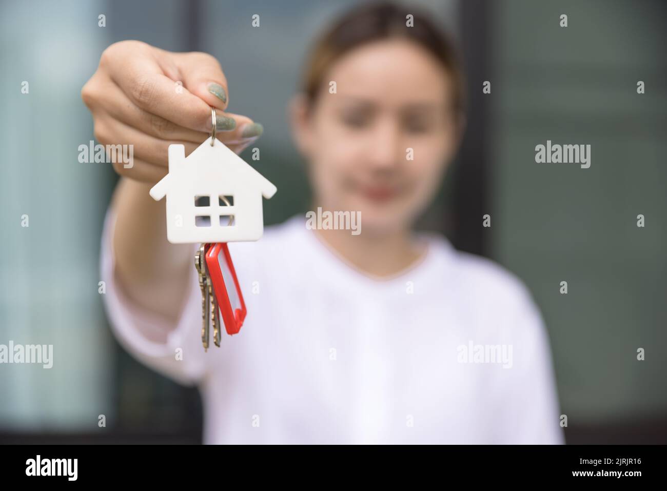 House key in hand, Female hand holding house key, real estate agent ...