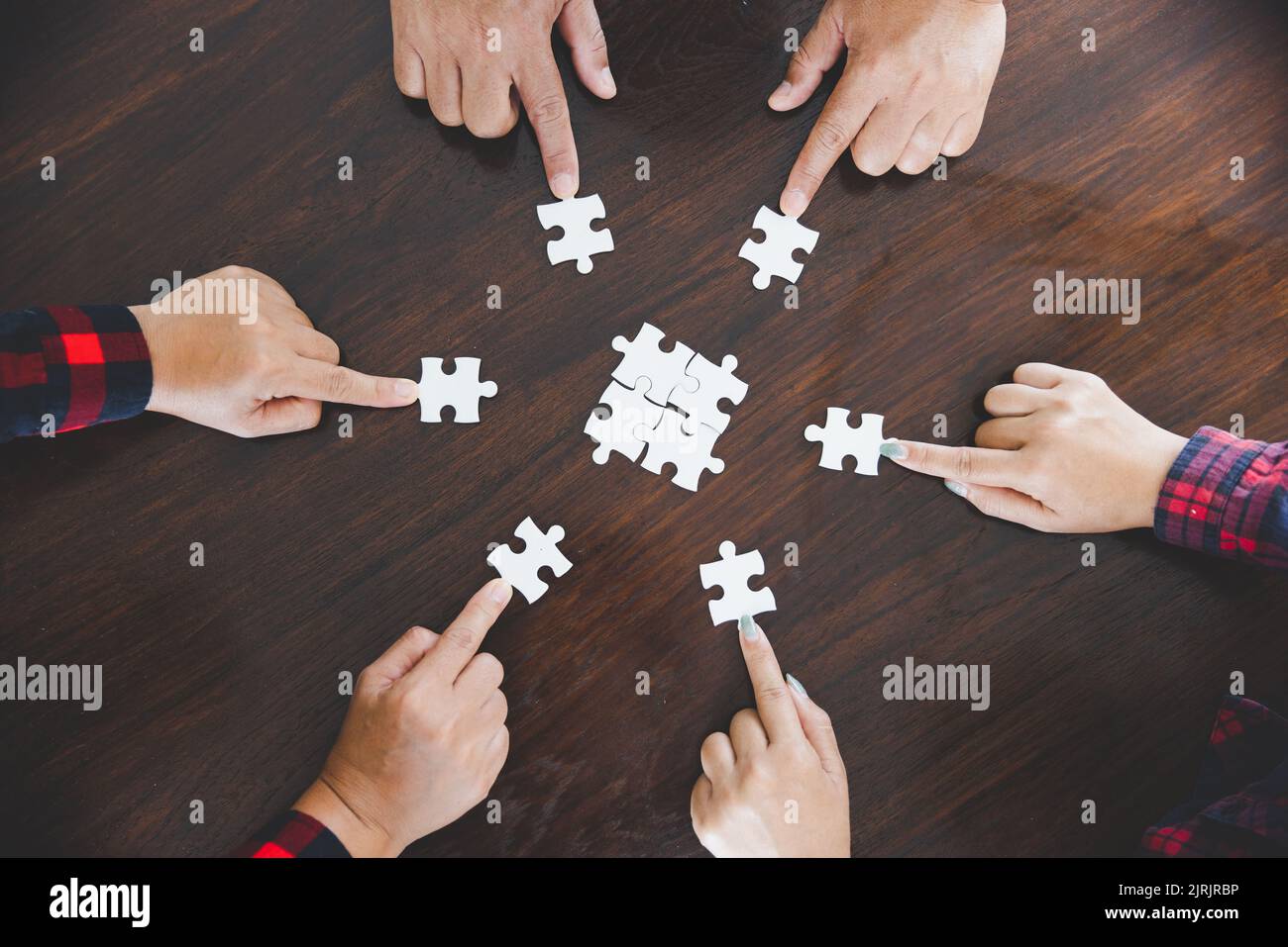 people helping in assembling puzzle, cooperation in decision making ...