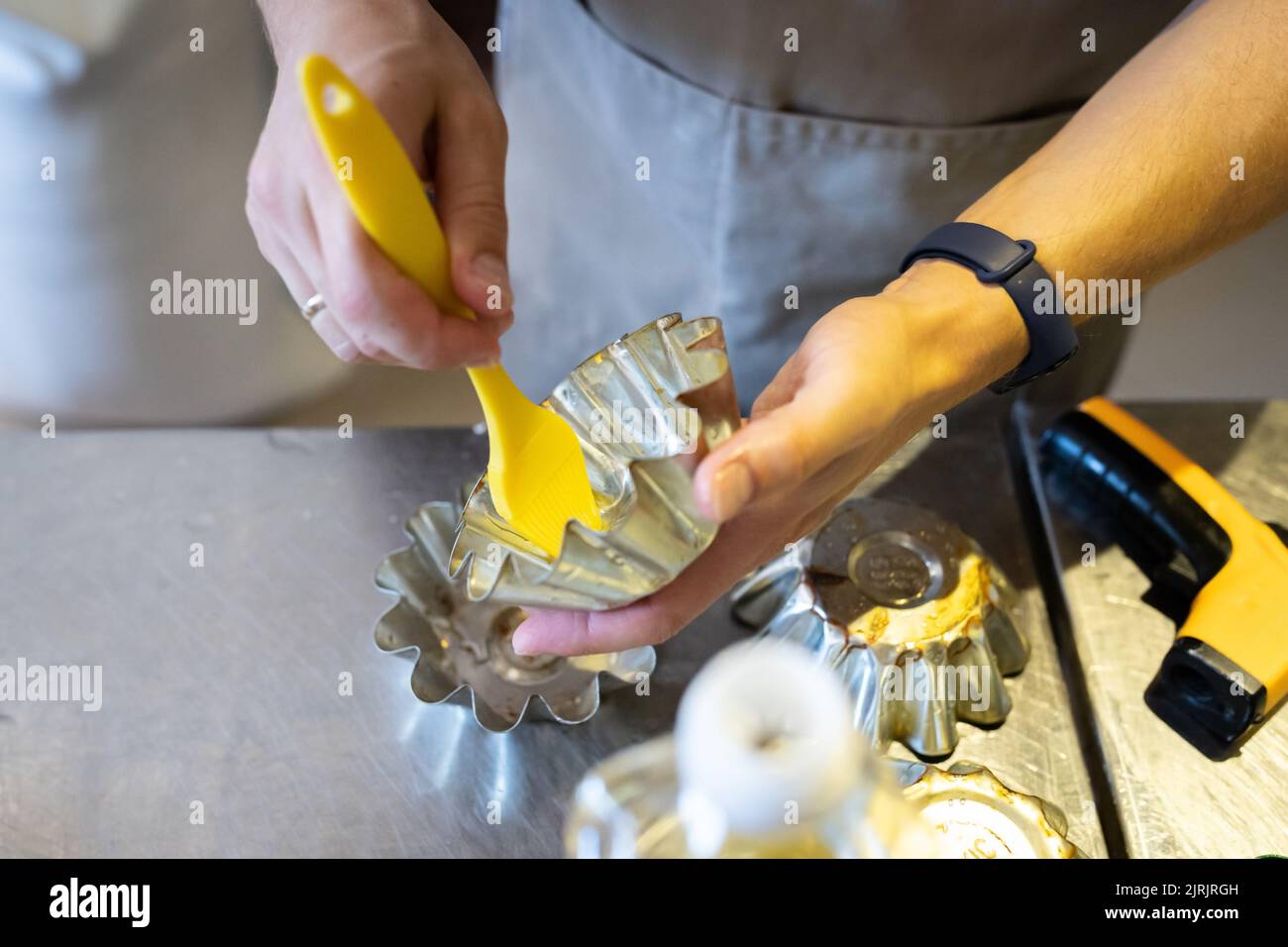 The process of making brioche in a craft bakery. Greasing baking molds ...