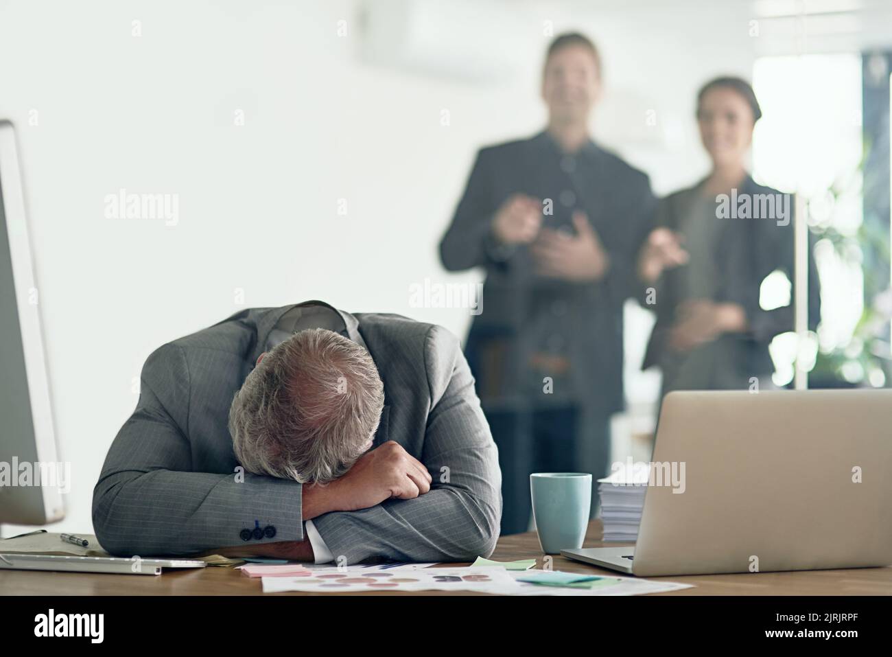 Bullying finds its way into the workplace. a dejected businessman lying ...