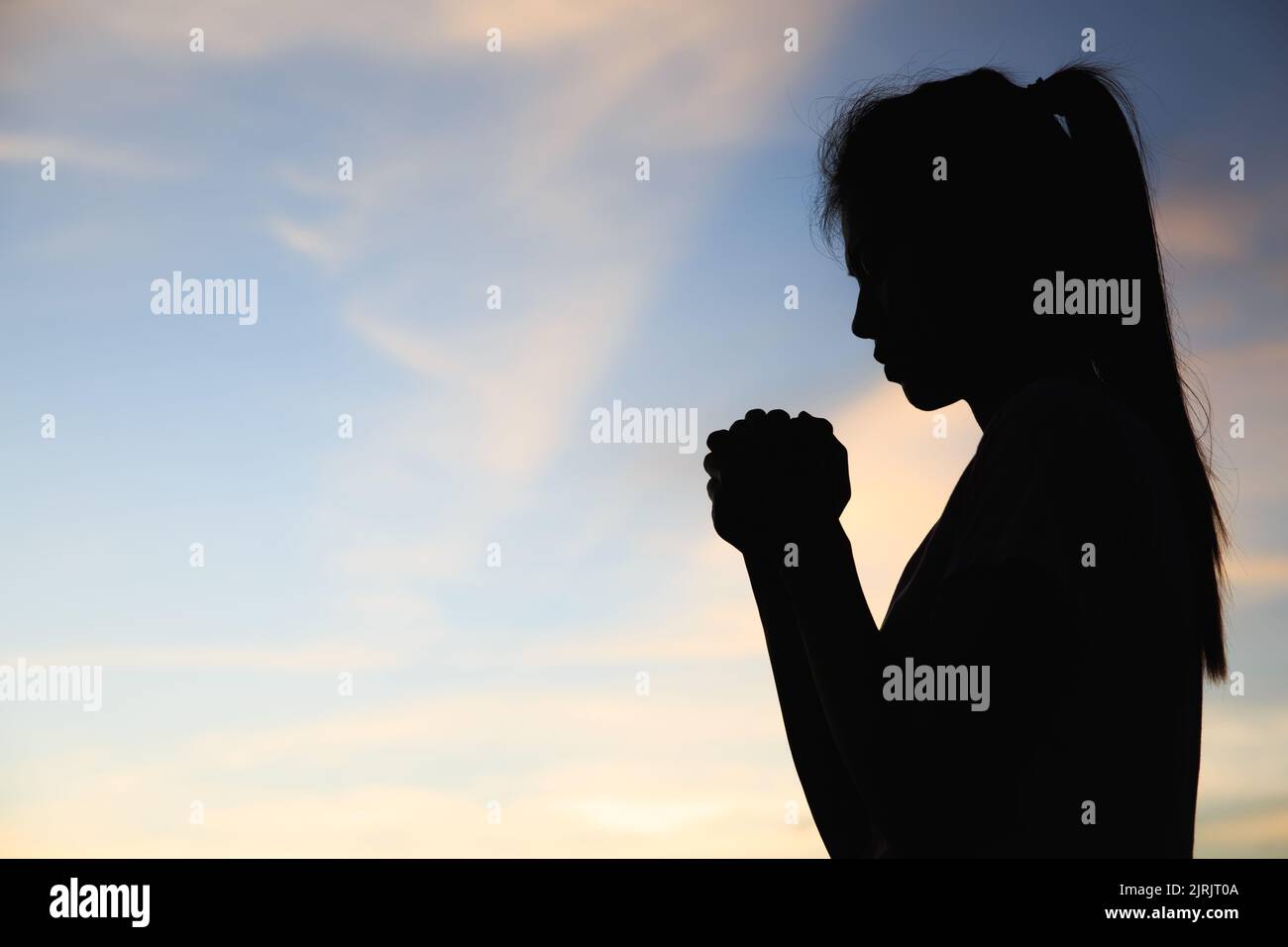 Silhouette of The girl prayed in the mountains to think of a loving God ...