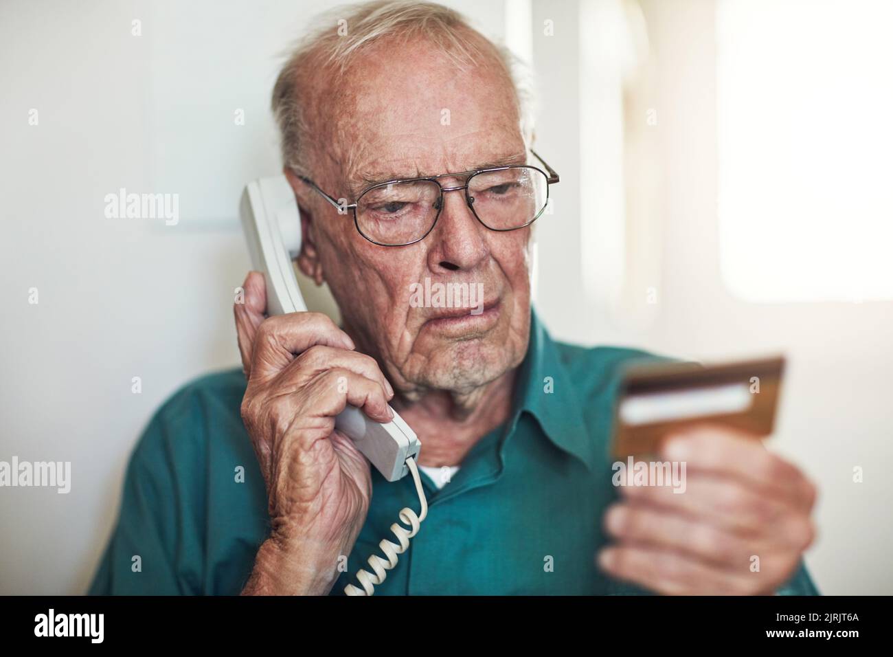 Can I make a booking. a senior man reading something off his credit ...