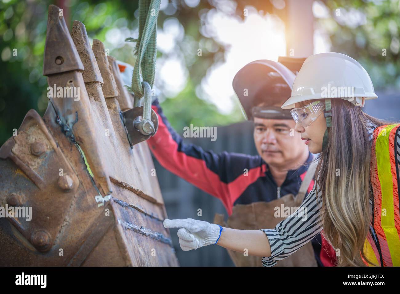 Portrait of a beautiful Asian engineer holding a wrench The background ...