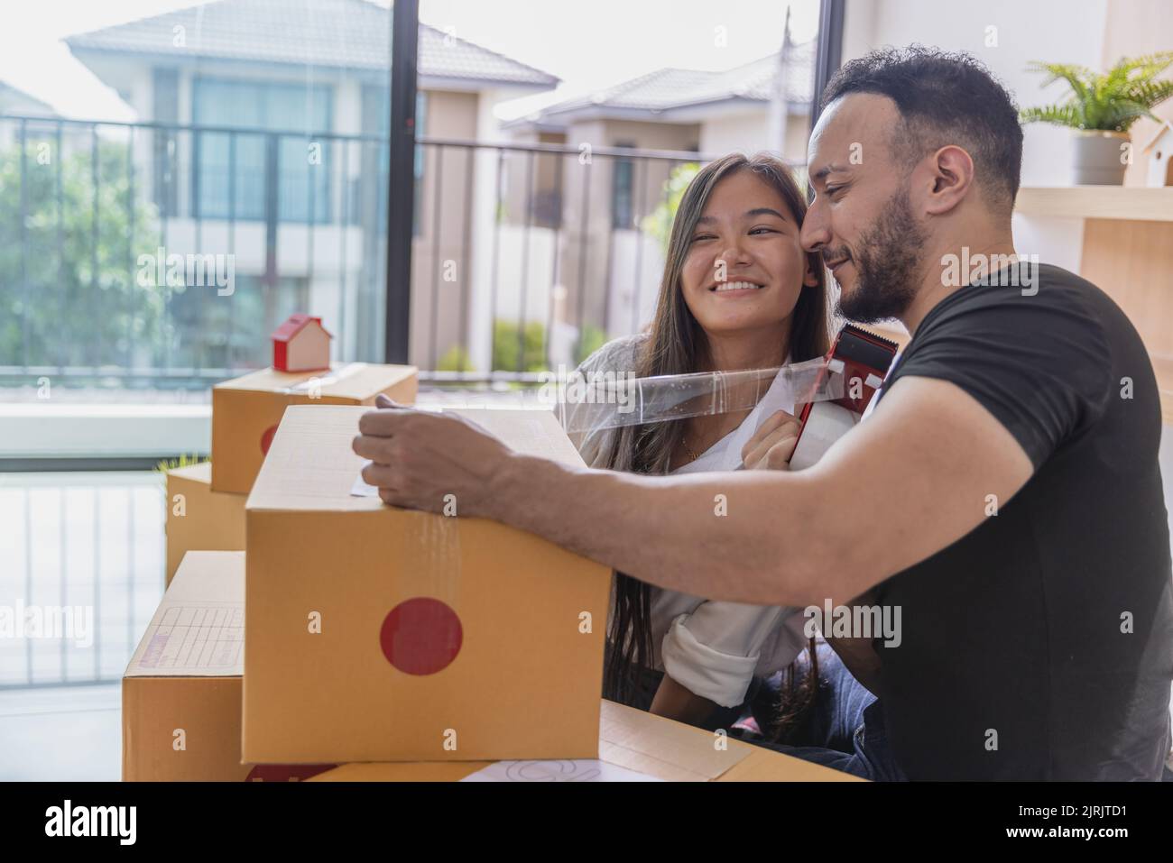 The concept of moving house. Closeup of Couple packing cardboard boxes ...