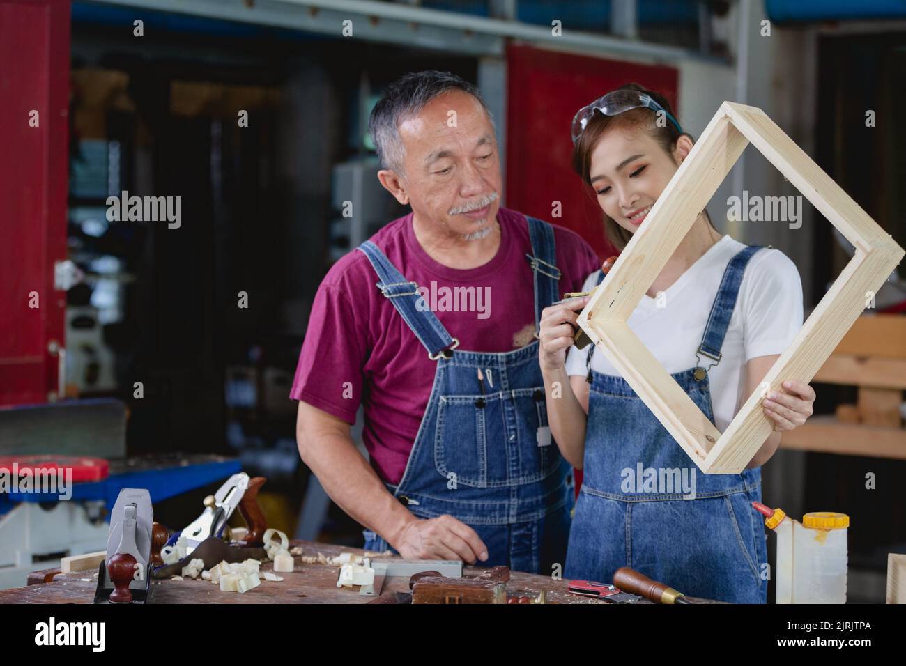 Two professional carpenters works in her own woodworking shop ...