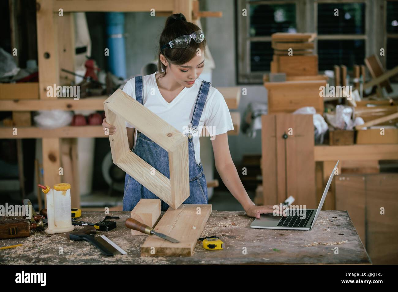 Professional carpenter. A woman works in a carpentry shop using a ...