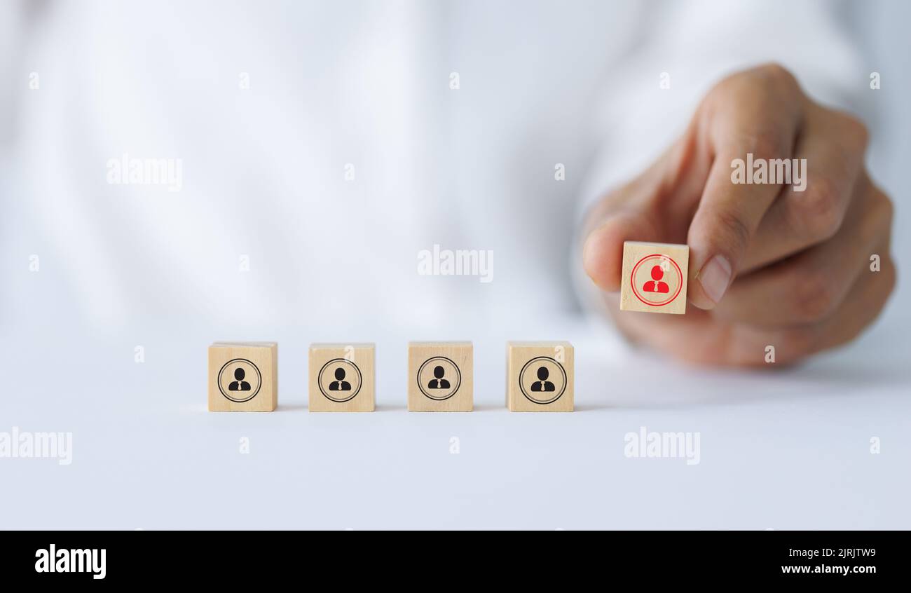 Hand holding a wooden block with people icon above mint square ...