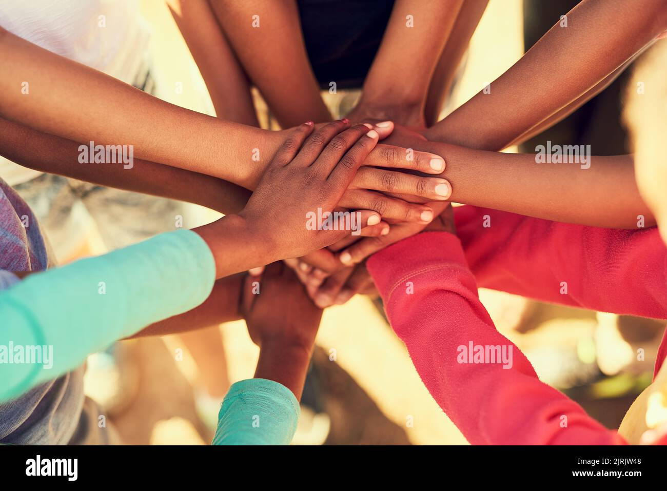 Friends forever. a group of children standing with their hands in a ...