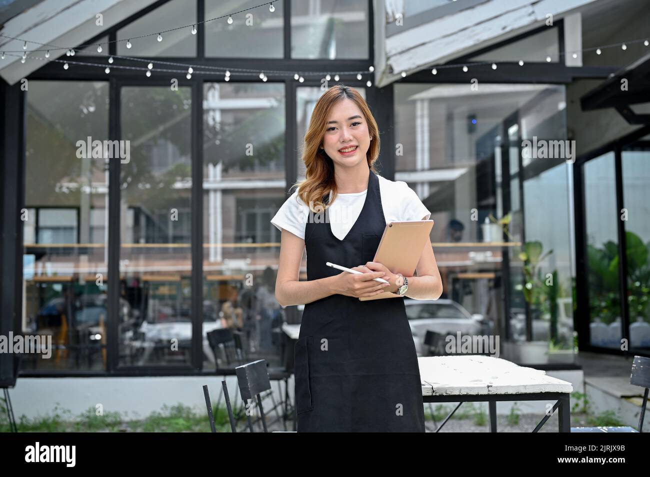 Charming and gorgeous young Asian female restaurant or coffee shop ...