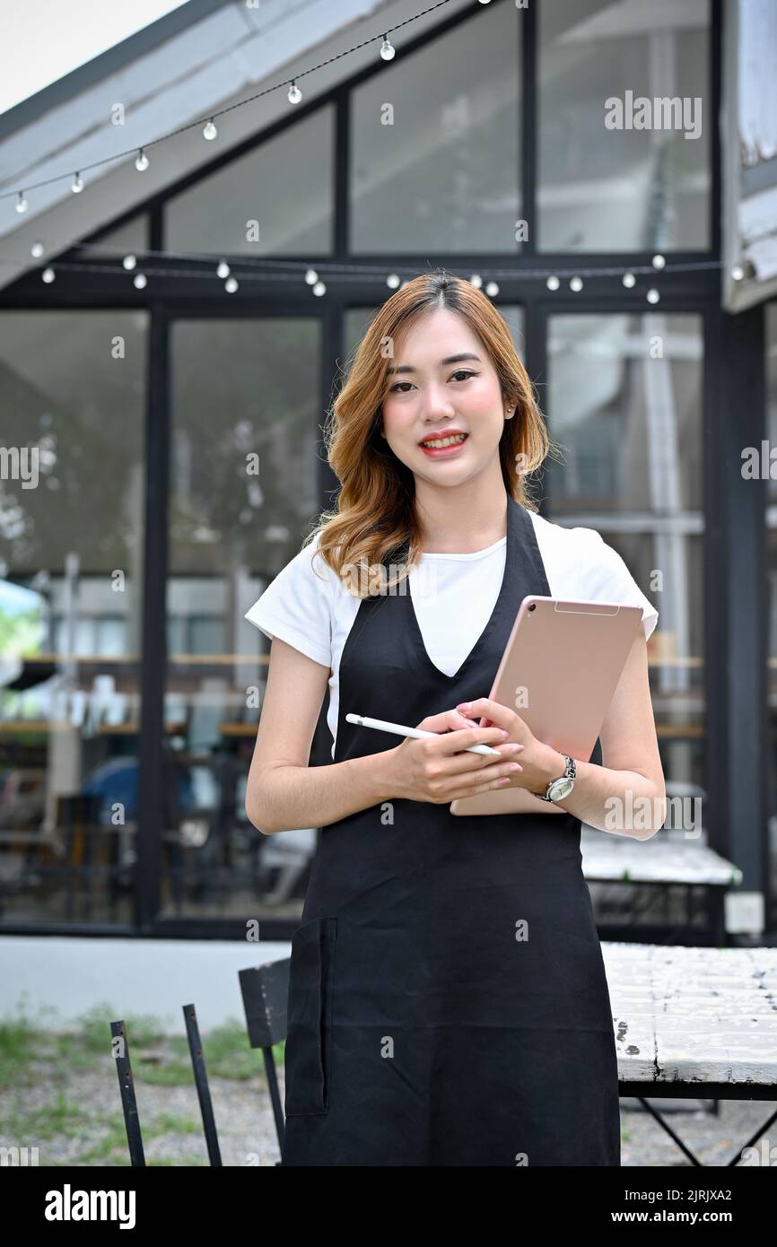 Portrait, Beautiful millennial Asian female waitress or restaurant ...