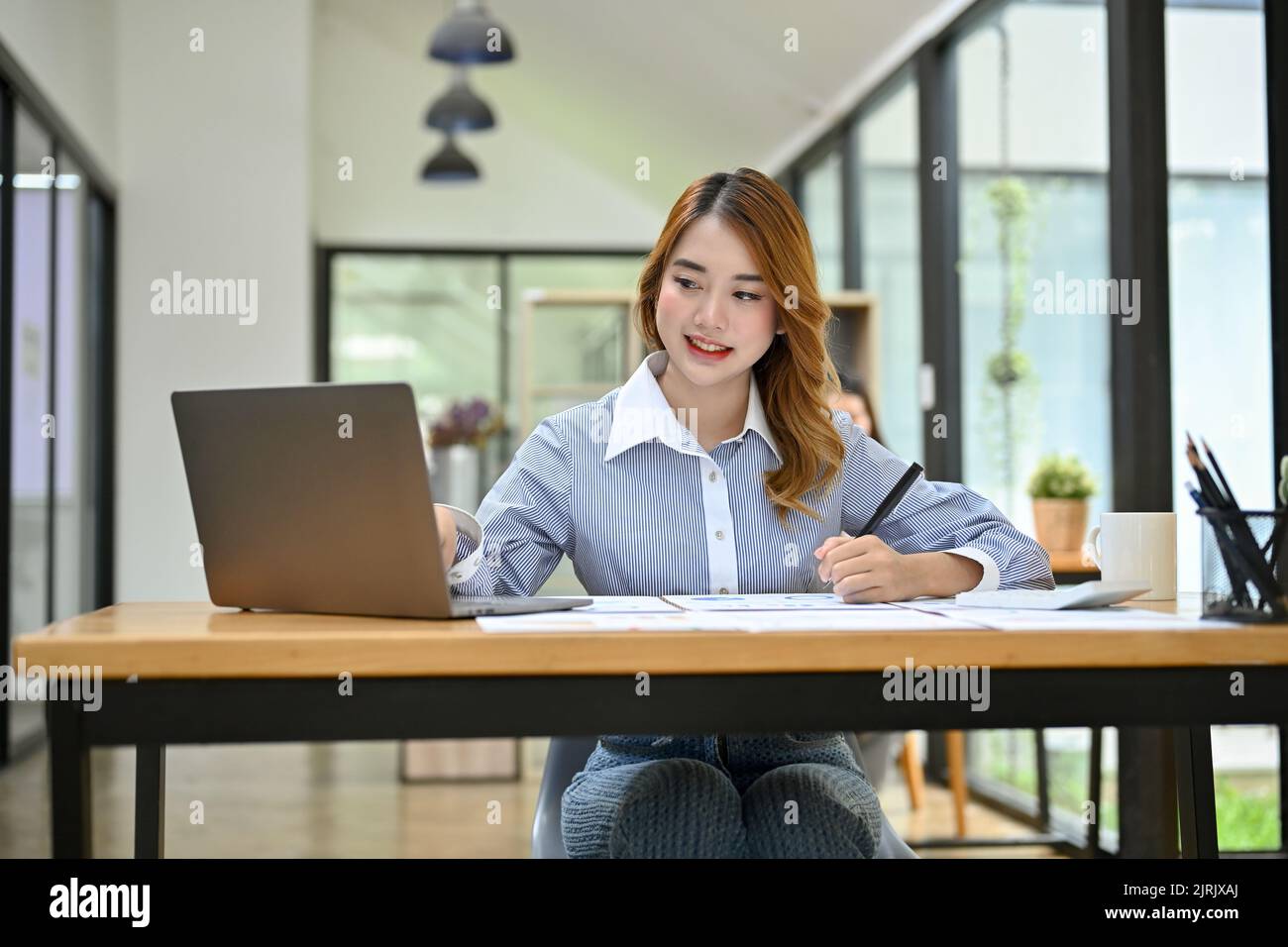 Attractive and gorgeous young Asian female accountant working on her ...