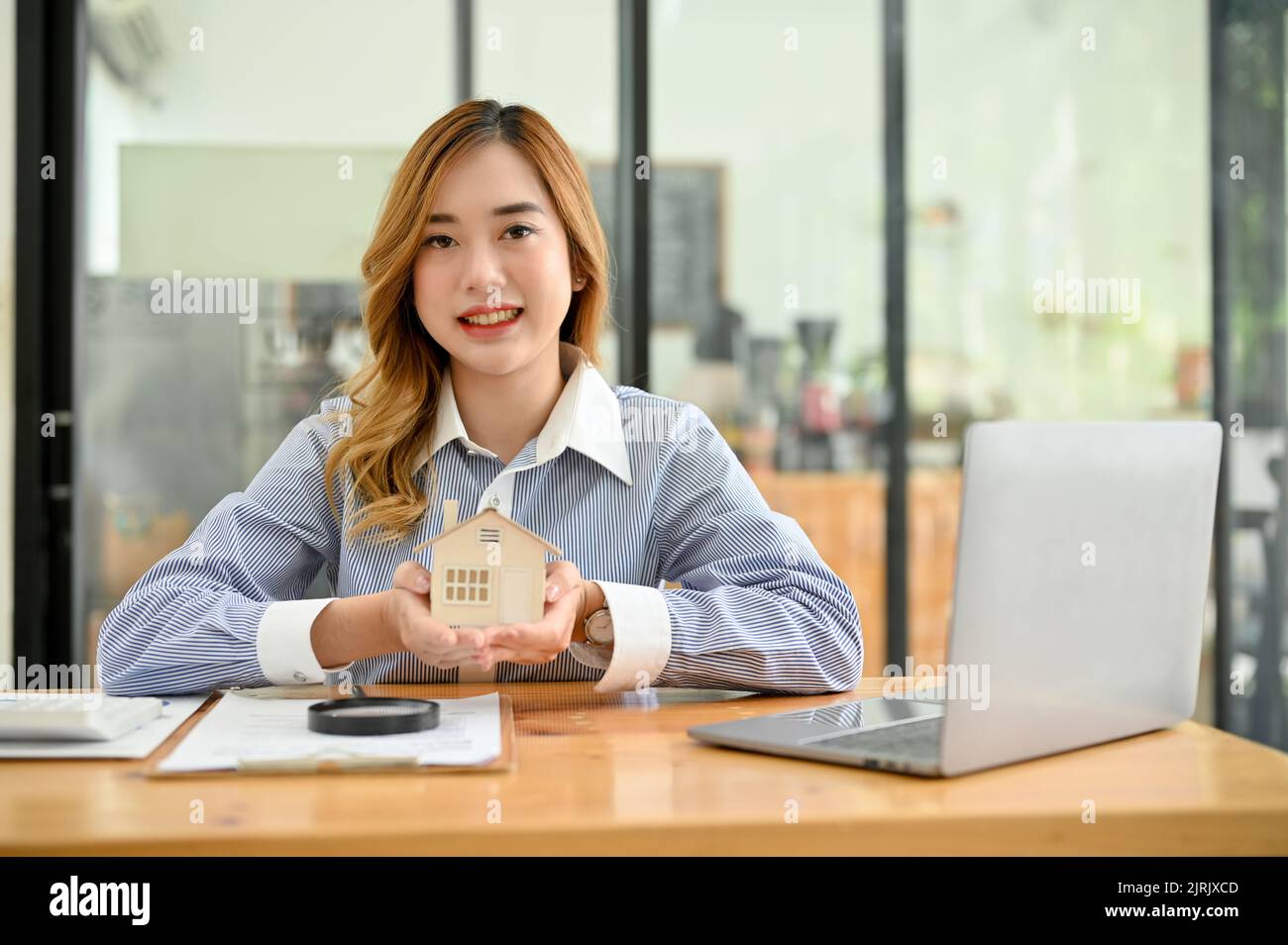 Beautiful Young Asian Female Real Estate Agent Or Realtor Holding Or Showing A House Model At