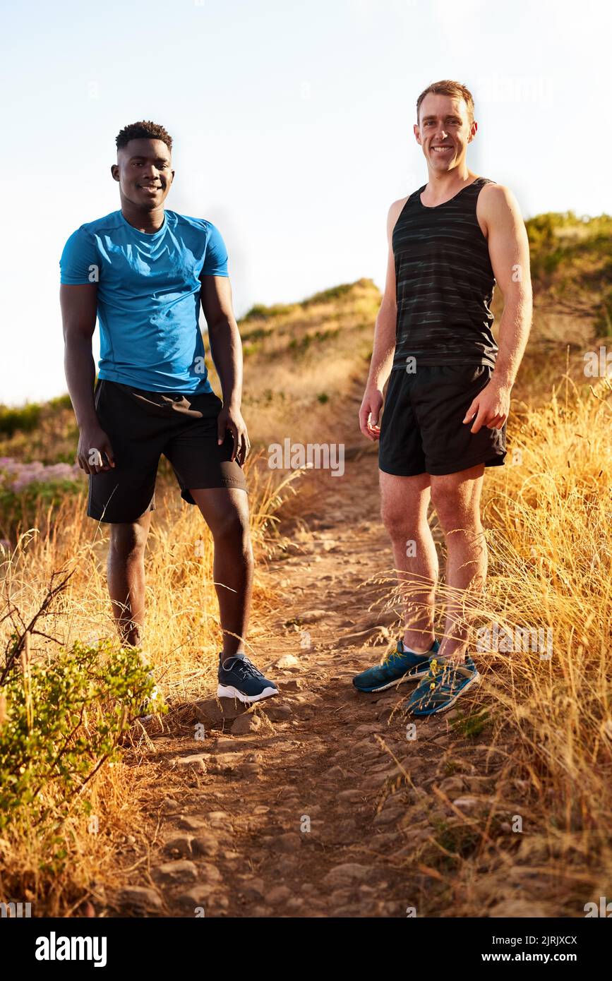Another day, another trail. two sporty young men out for a run together ...