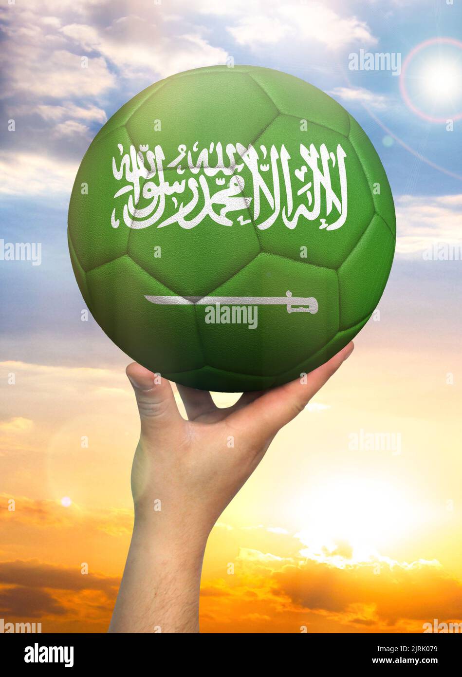 Soccer ball in hand with a depiction of the flag of Saudi Arabia ...