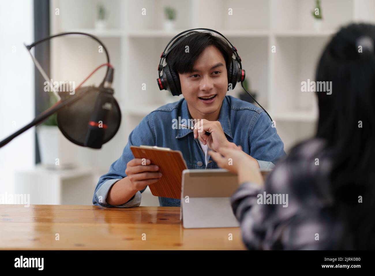Asian podcaster making audio podcast working with guest at home studio ...