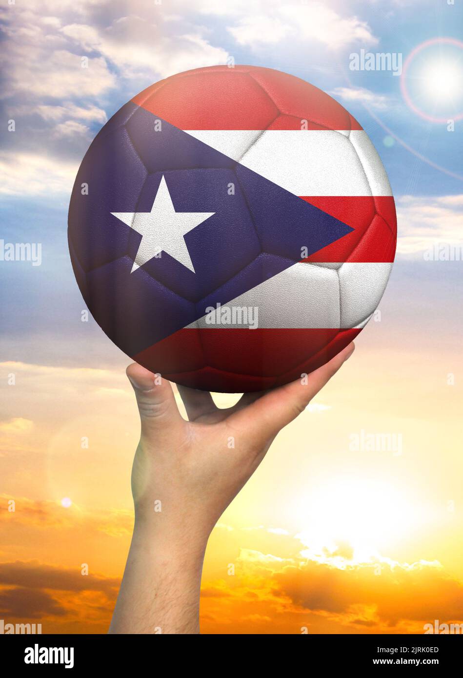 Soccer ball in hand with a depiction of the flag of Puerto Rico against ...