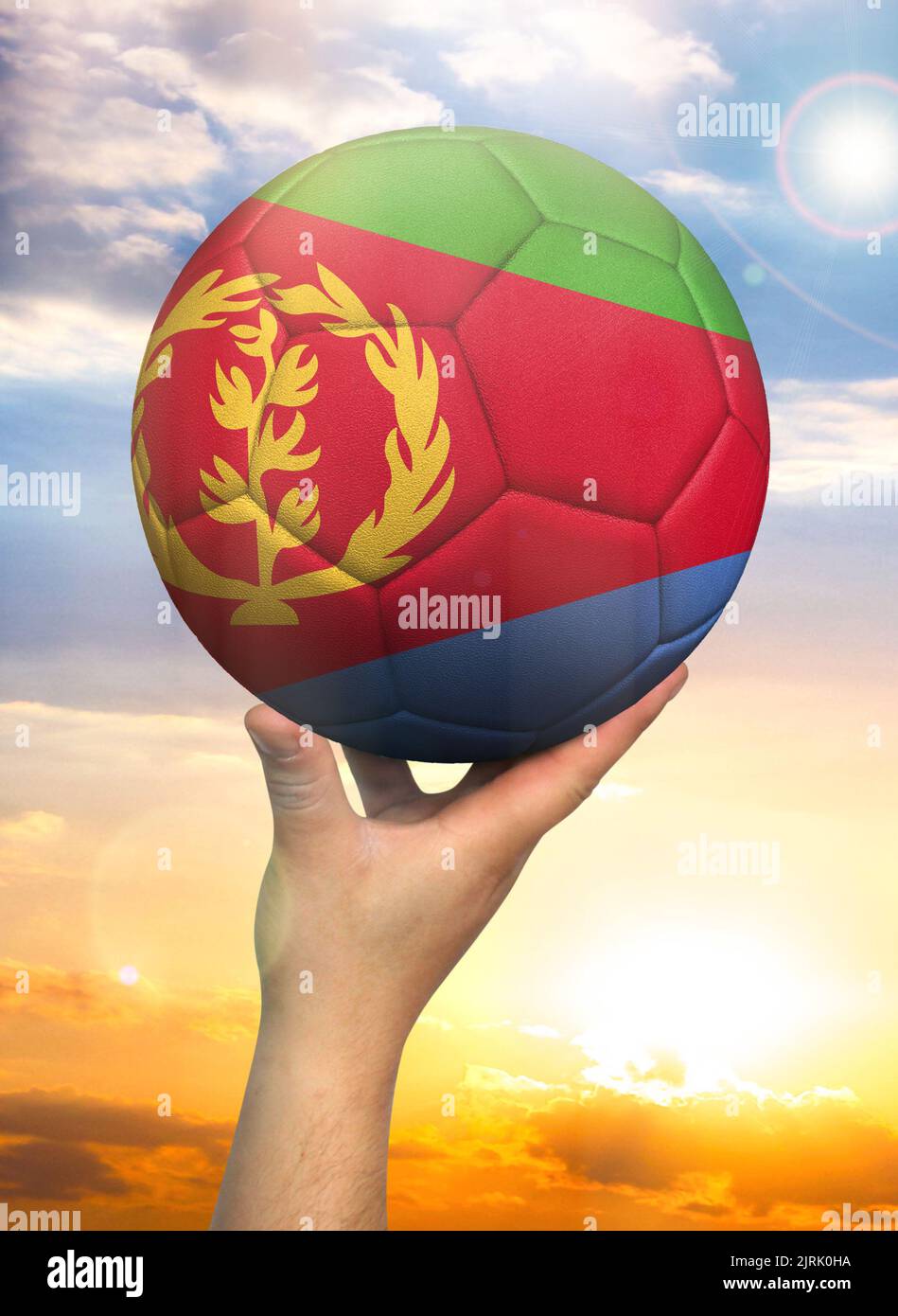 Soccer ball in hand with a depiction of the flag of Eritrea against a ...