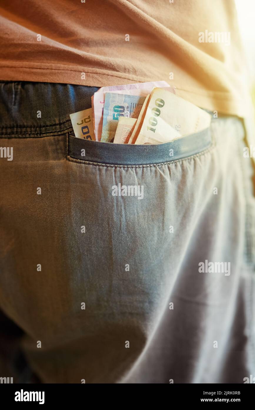 Burning a hole in his pocket. Cropped closeup shot of a many with Thai ...