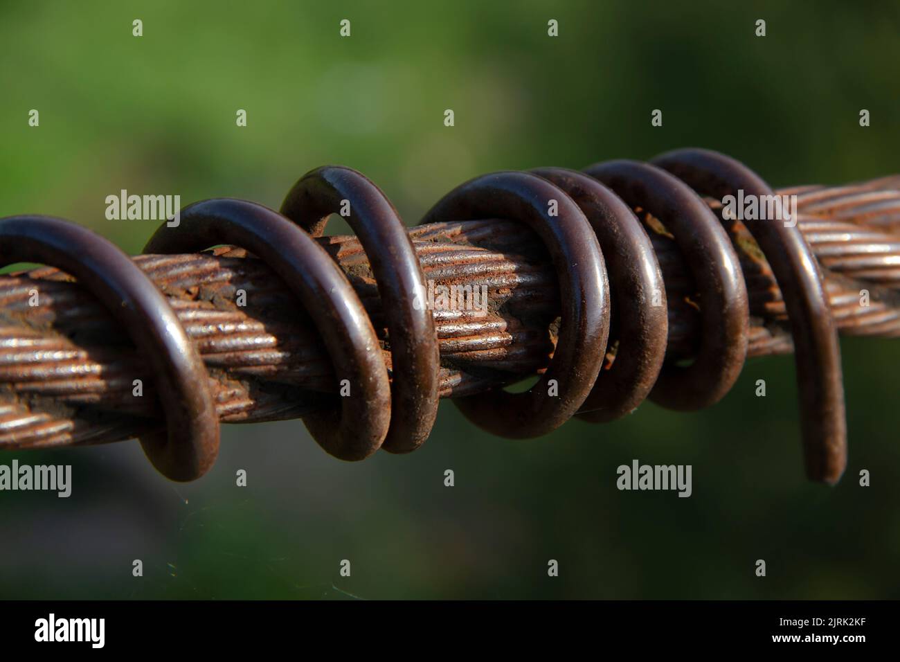 Rope old rusty and wire on a green background of trees Stock Photo - Alamy