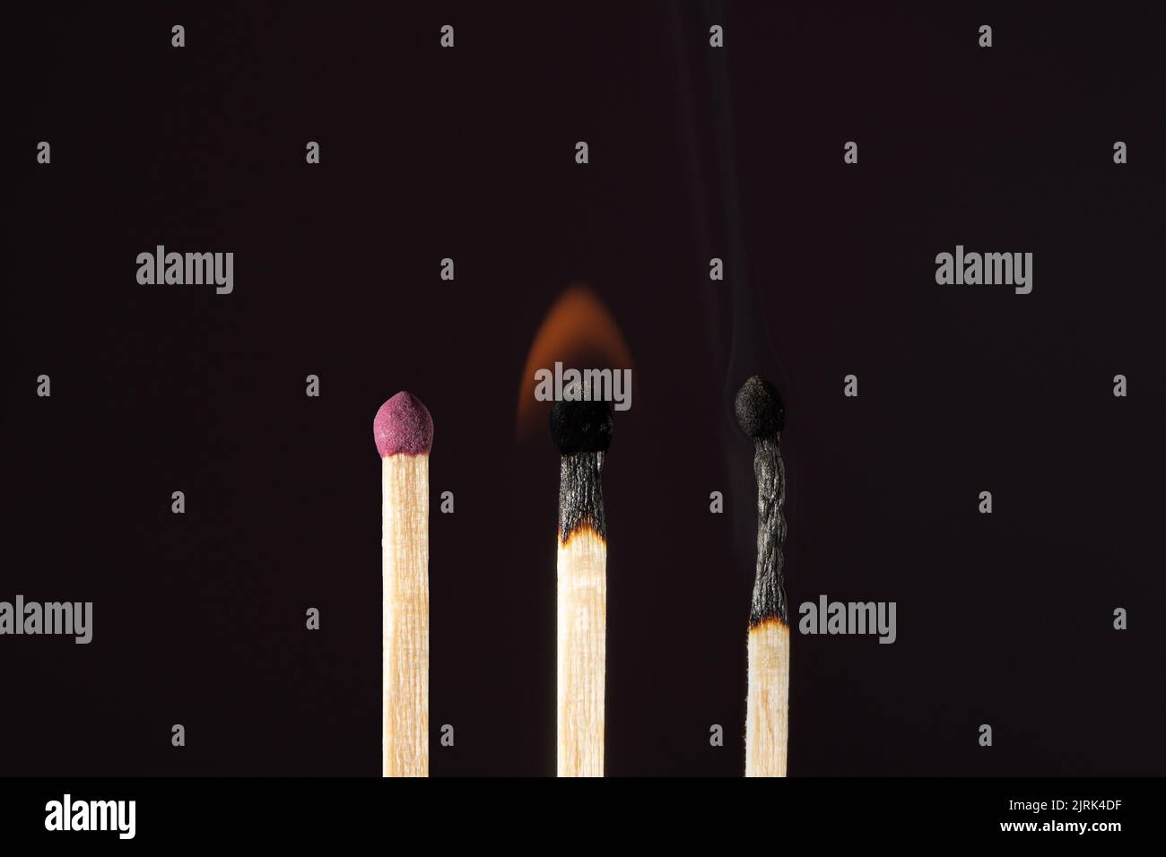 Three stages of burning matches on a dark background. Matches with a ...