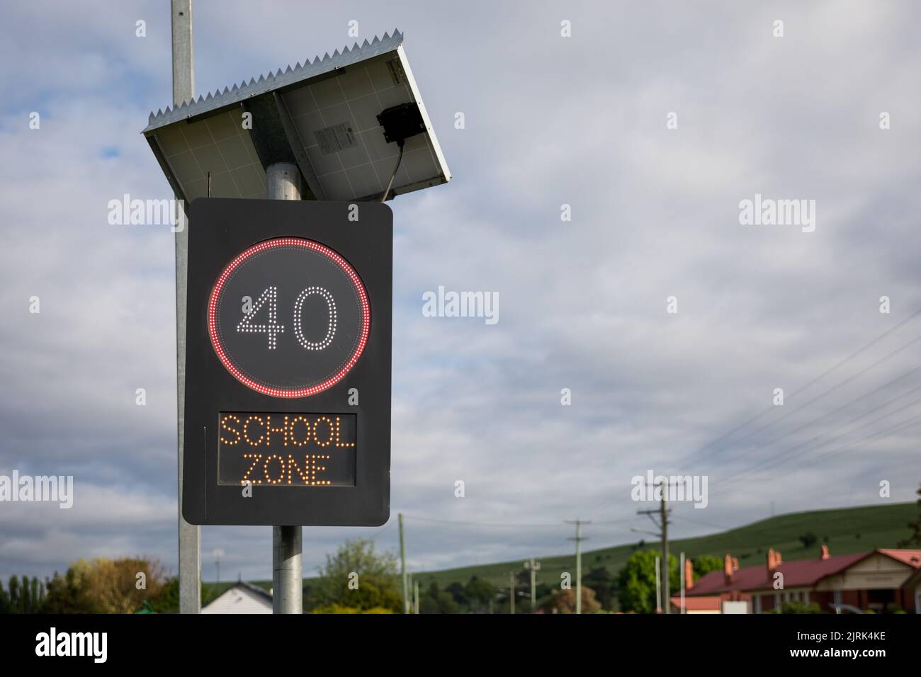 A closeup of a digital road sign of 40 speed limit near a school zone ...