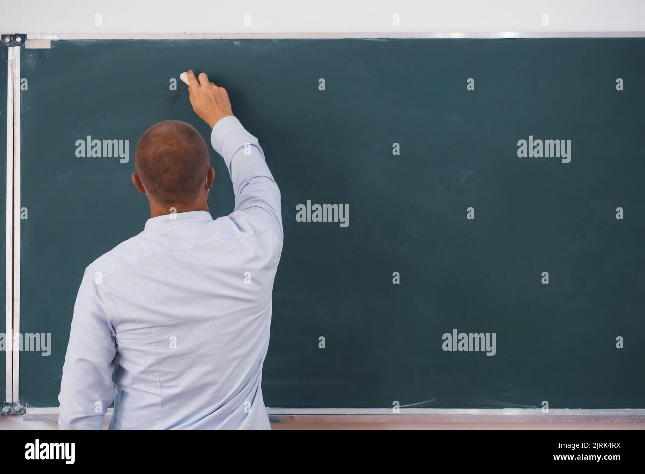 Teacher or student writing on blackboard in school classroom Stock ...