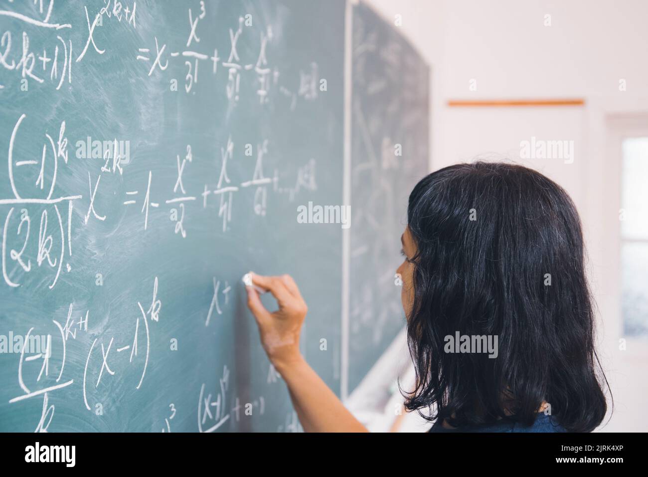 Teacher or student writing on blackboard during math lesson in school ...